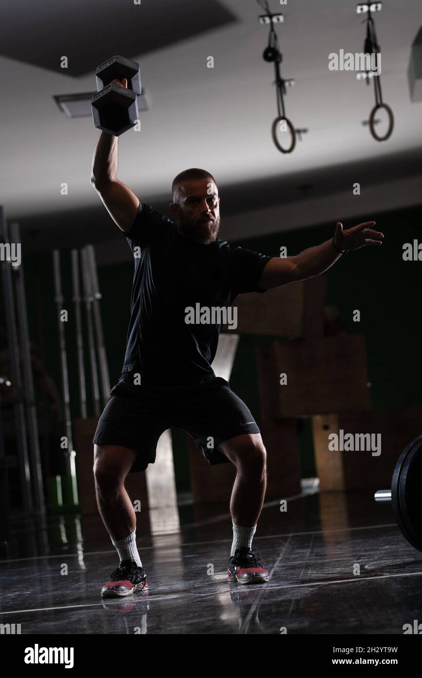 Silhouette of a muscular athlete lifting very heavy weights. Man ...