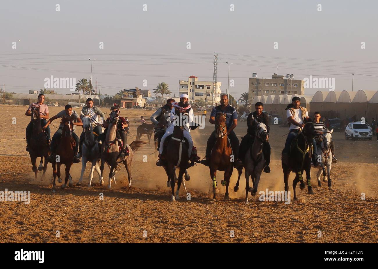 Gaza. 24th Oct, 2021. Palestinian jockeys ride horses as they take part ...