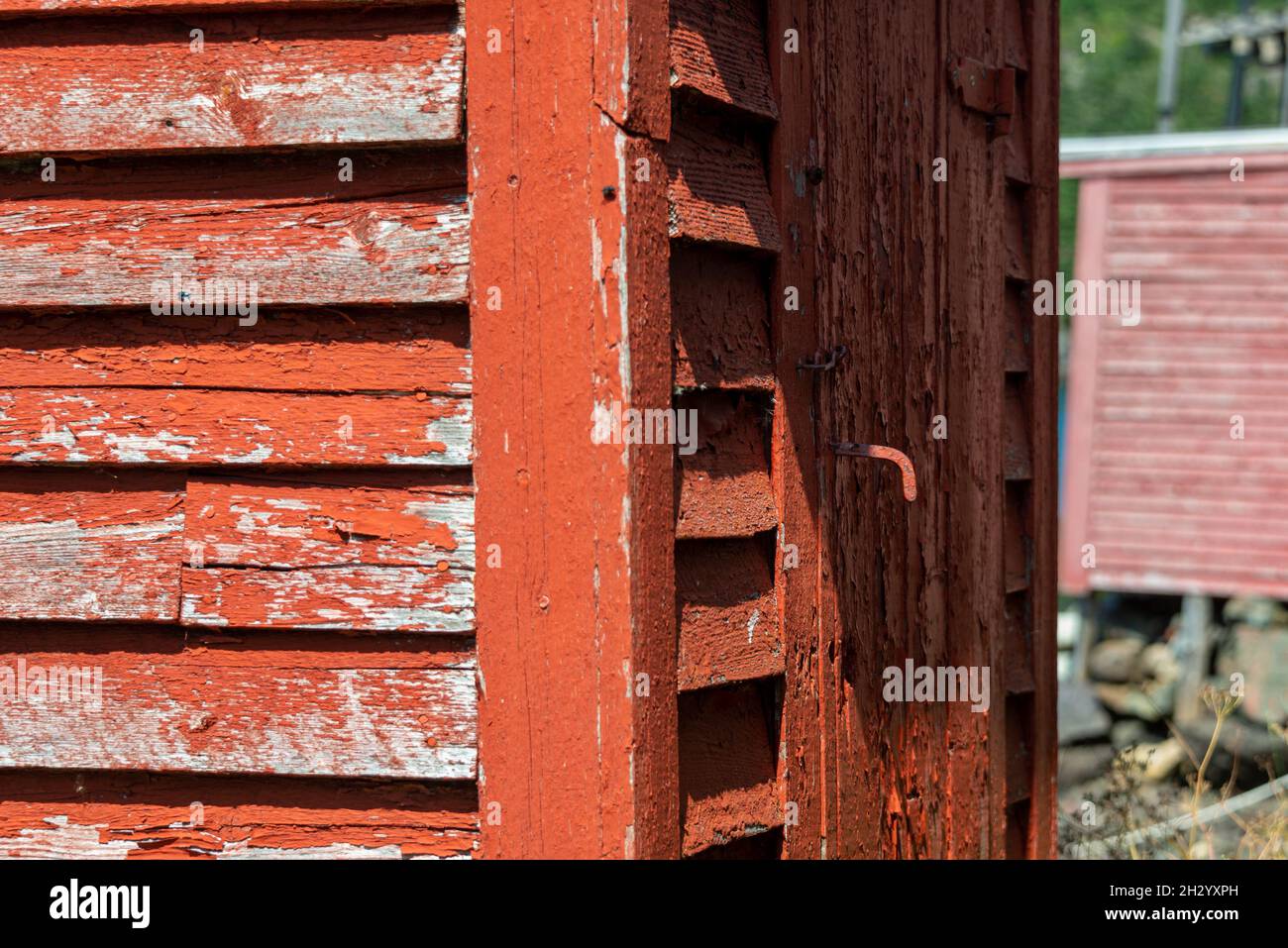 The exterior corner view of a vintage bright red storage building or ...