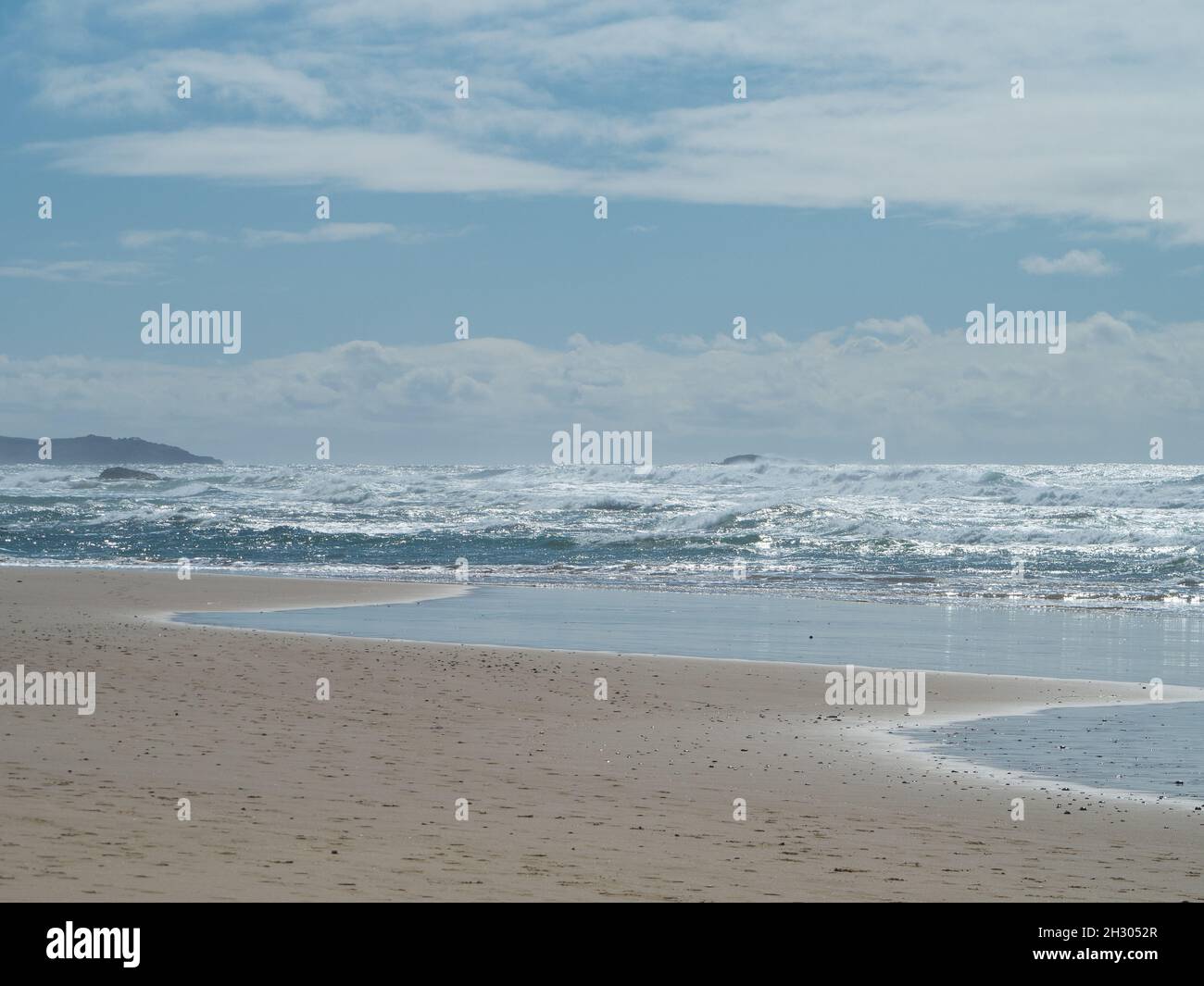 Beautiful seaside. Shades of pale blue and sand in the beach and waves ...
