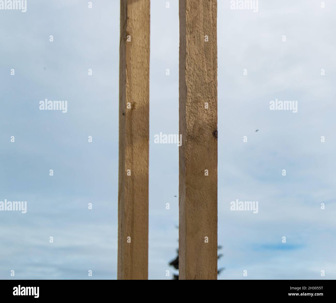 Two wooden vertical beams on a blue sky background Stock Photo - Alamy