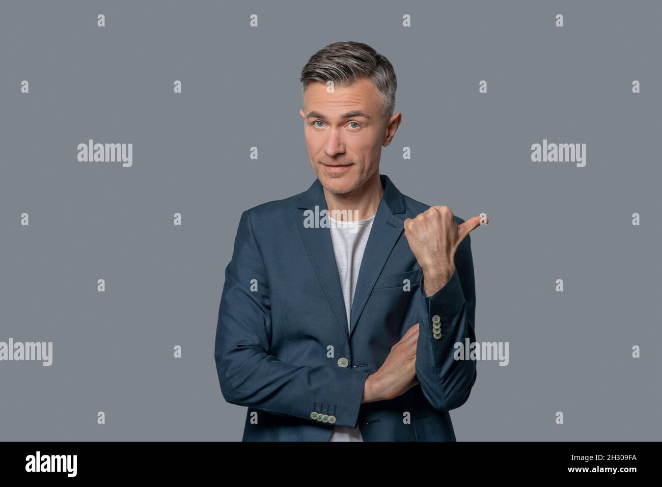 Amazed man pointing back and to side Stock Photo - Alamy
