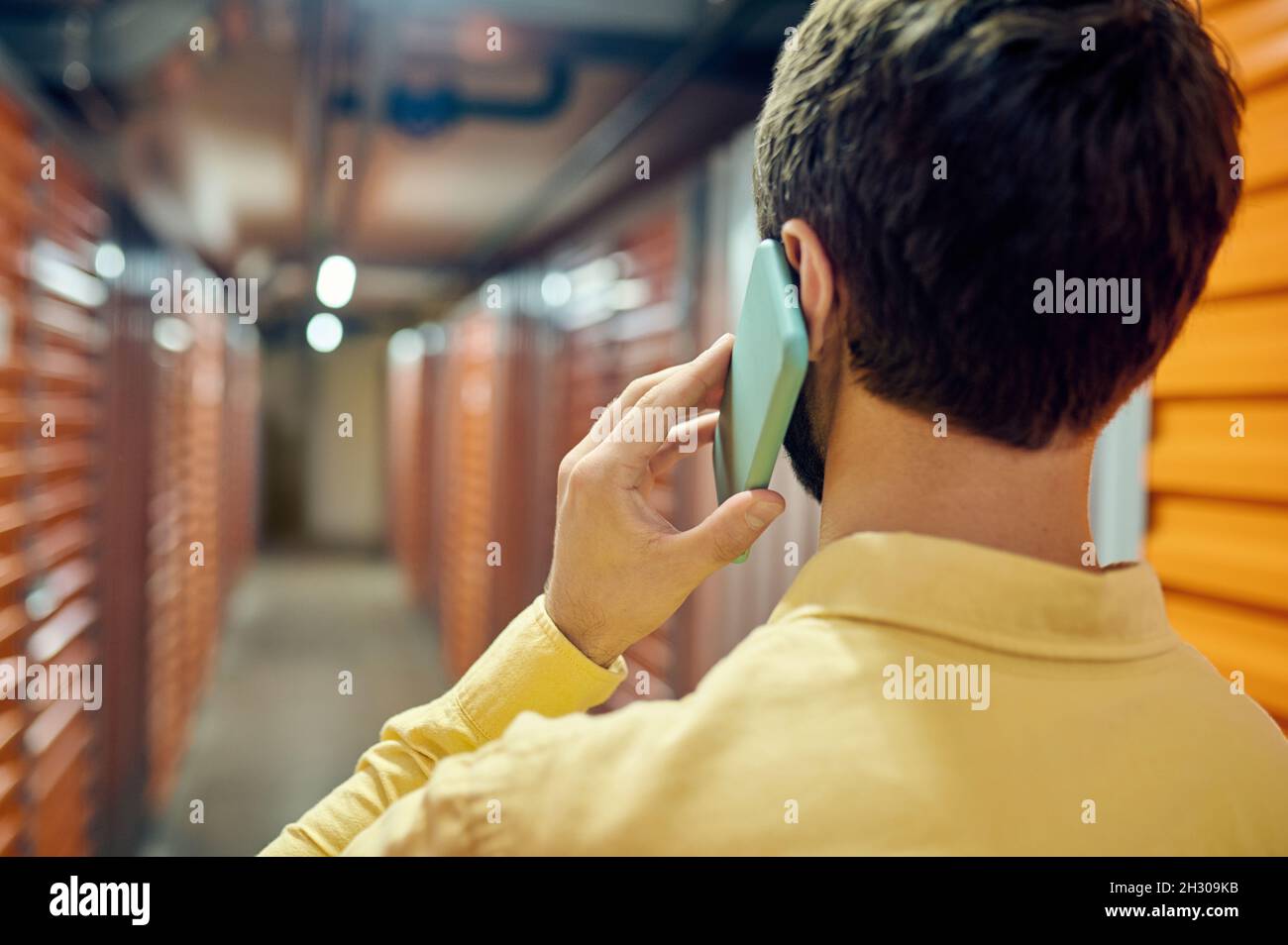 Man with back to camera with smartphone near ear Stock Photo - Alamy