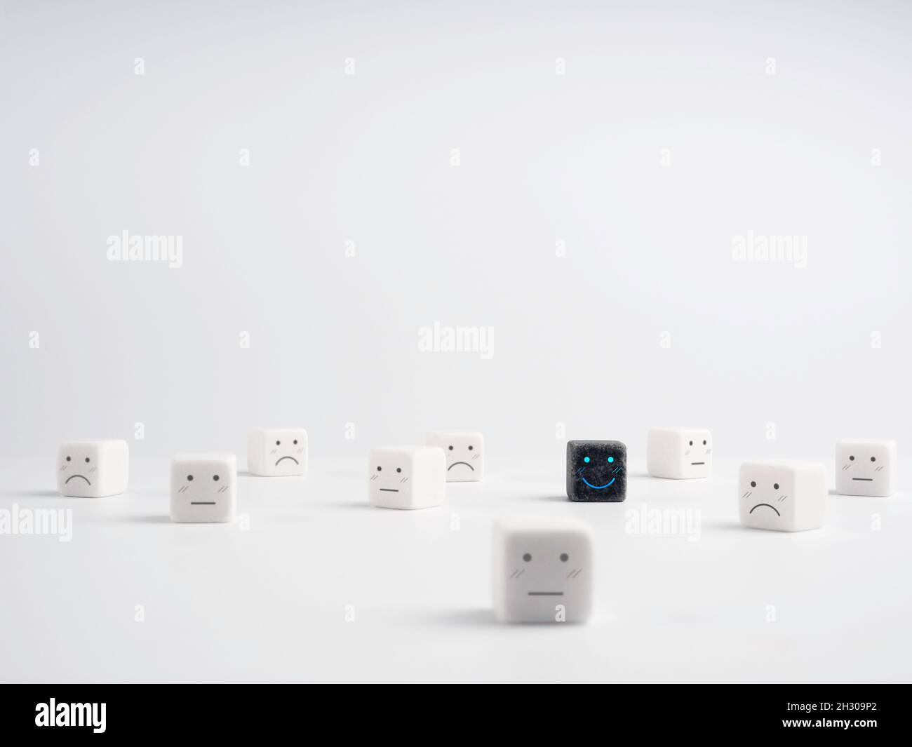 Black dice with smile face standing out from crowd, white dice with ...