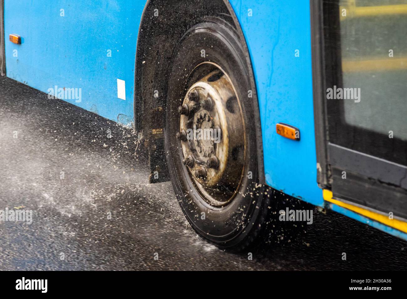 blue municipal bus moving on rainy road with water splashes Stock Photo ...