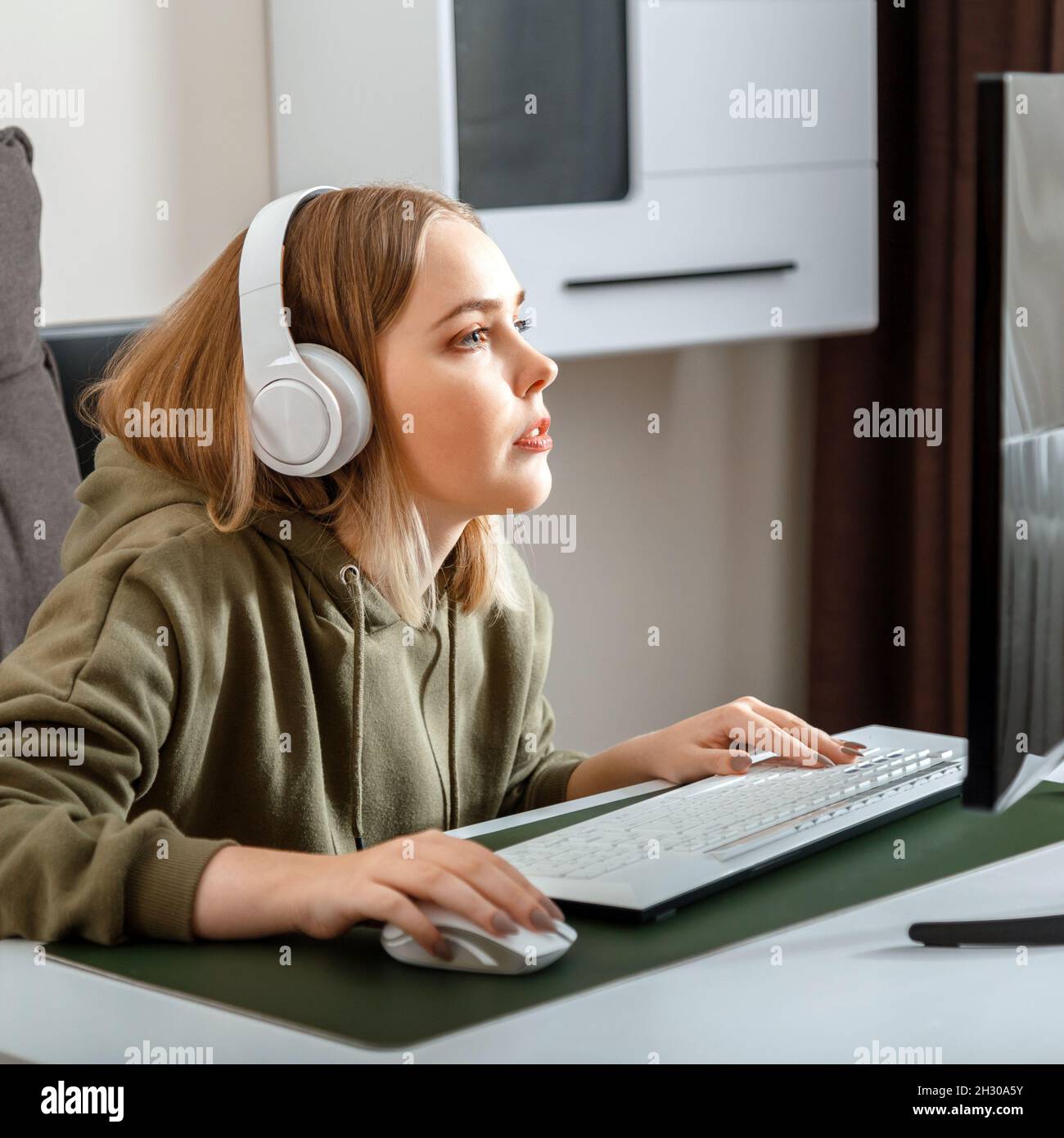 Teenager girl cybersportman gamer play online computer game at home ...