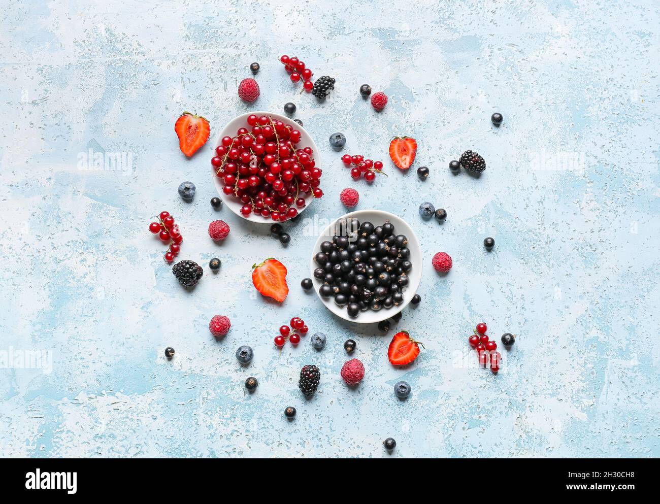 Bowls with tasty berries on color background Stock Photo - Alamy