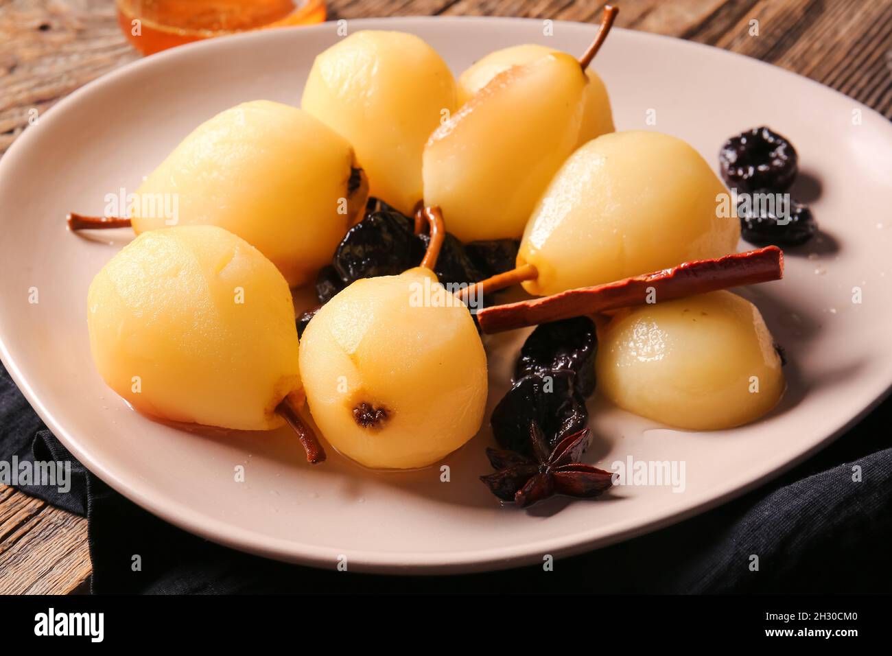 Dish with delicious poached pears, prunes, anise and cinnamon on table ...