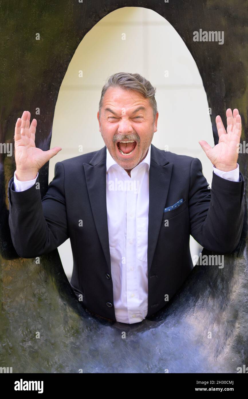 Emotional stylish man yelling at the camera and gesturing with his ...