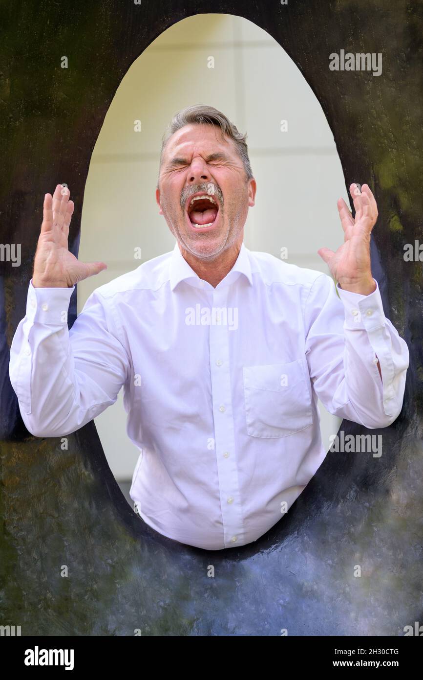 Vintage style photo in oval frame of a man middle-age screaming and ...