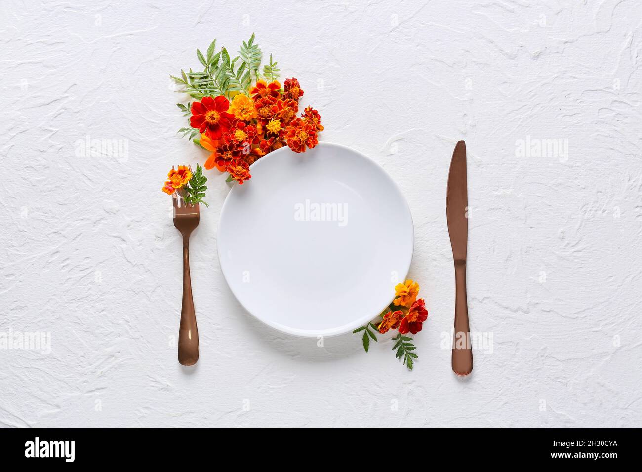 Beautiful table setting with blooming marigold flowers on light ...