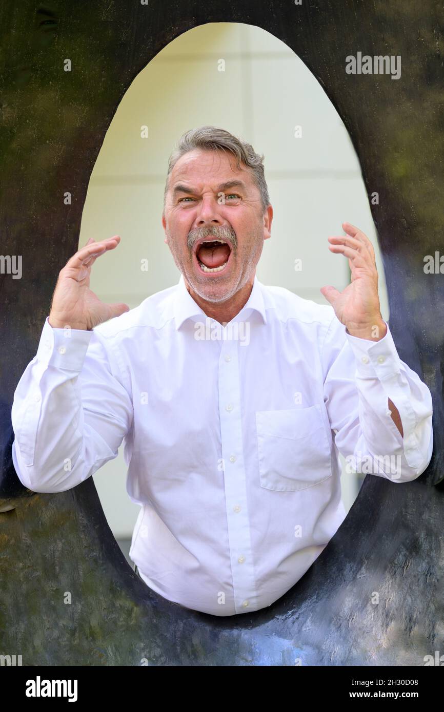 Vintage style photo in oval frame of a man middle-age screaming and ...
