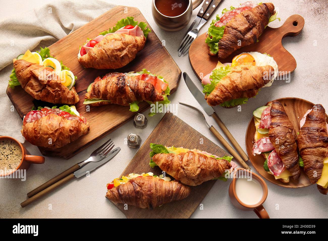 Wooden boards with delicious croissant sandwiches on white background ...