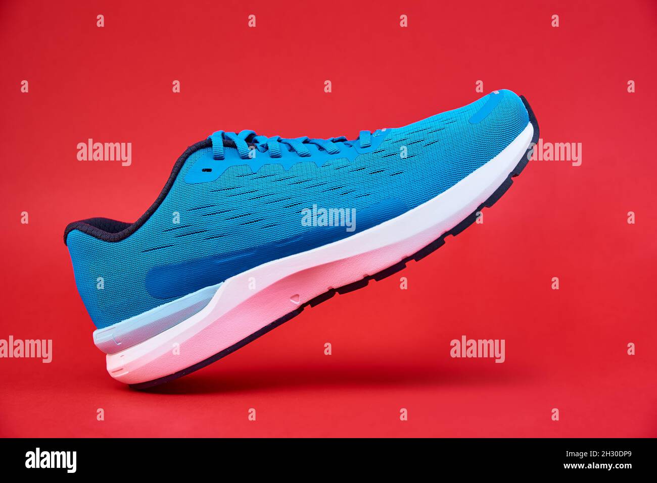 Blue running sneaker on red background. Sport male shoe steps on red ...