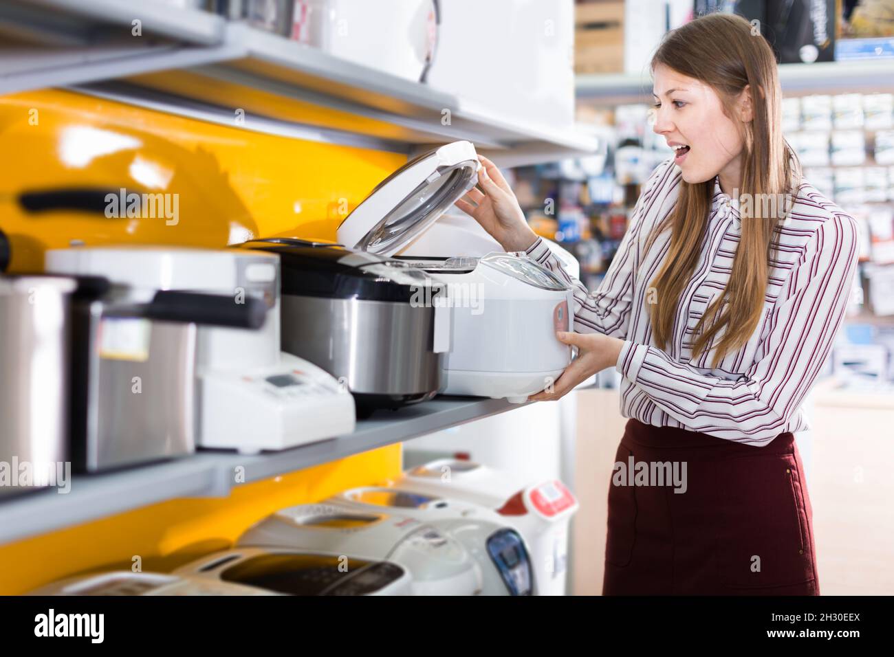 Young attractive female housewife choosing multicooker Stock Photo - Alamy