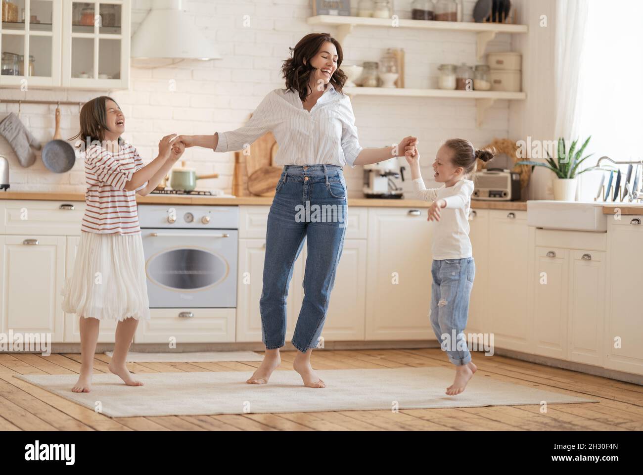 Mom and her daughters children girls are dancing. Family holiday and ...