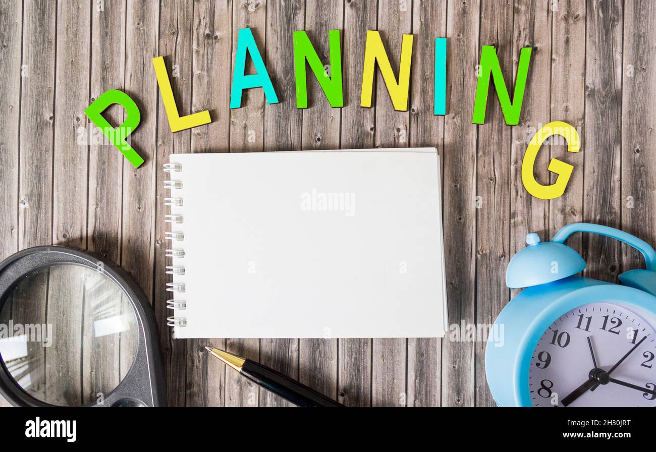 The word Planning consists of colored letters, next to a notepad for ...