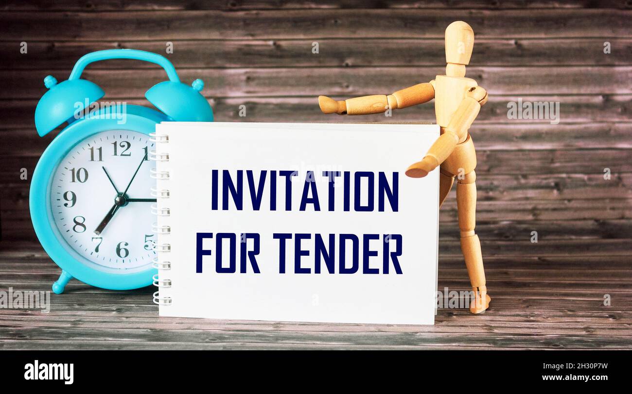 Notepad with and notes with wooden doll and clock and text INVITATION ...
