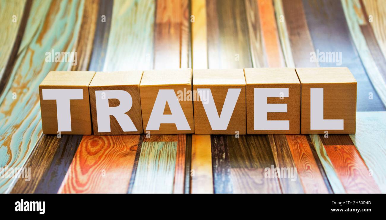 TRAVEL word concept written on wooden cubes blocks lying on a light ...