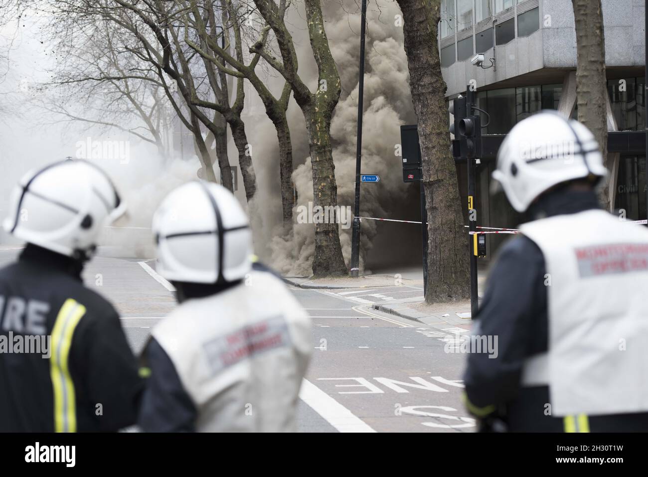 Fireman watch on as smoke rises from an underground cable fire on ...