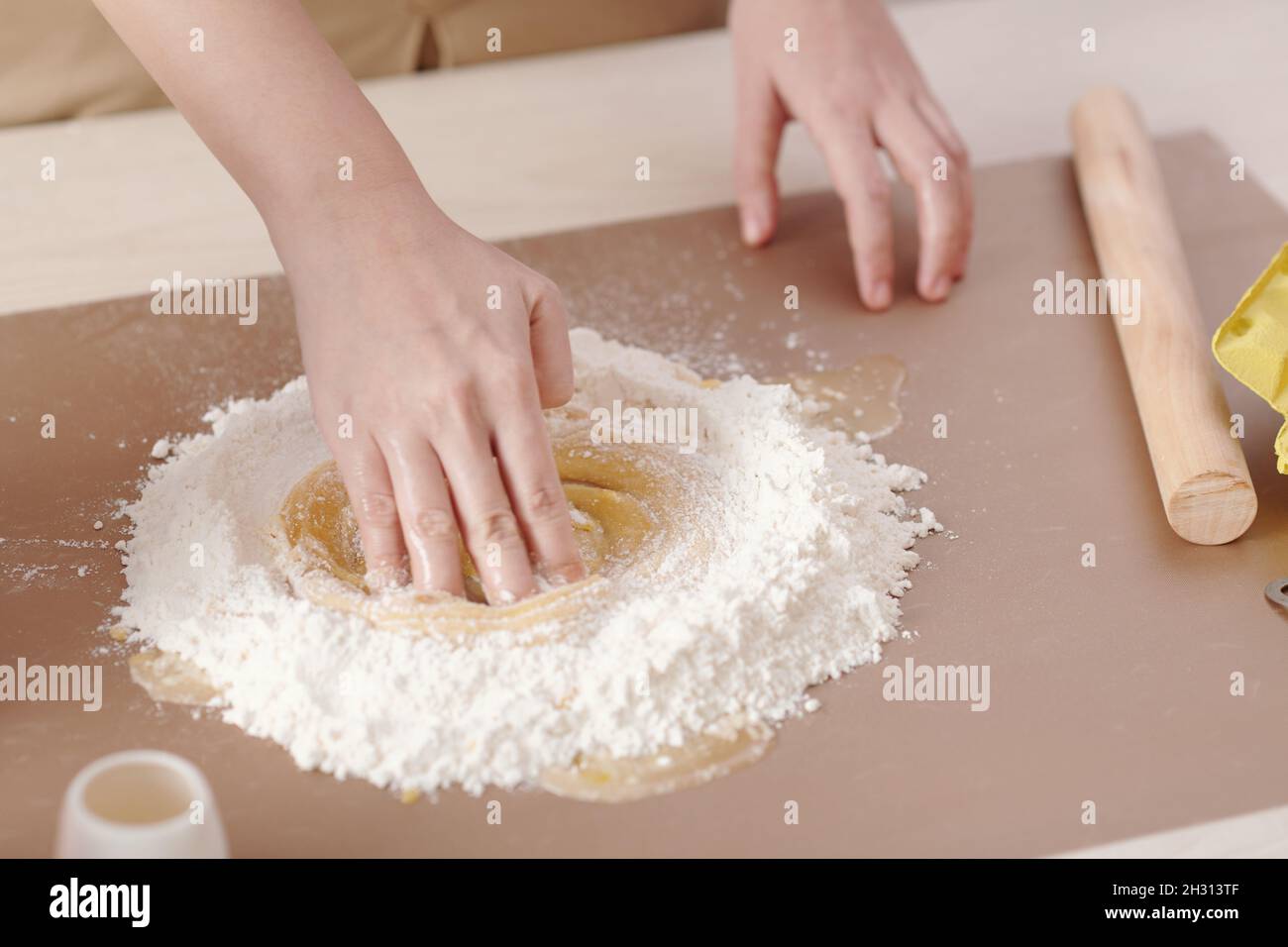 Hands of woman making circle motion to mix liquid and dry ingredients ...