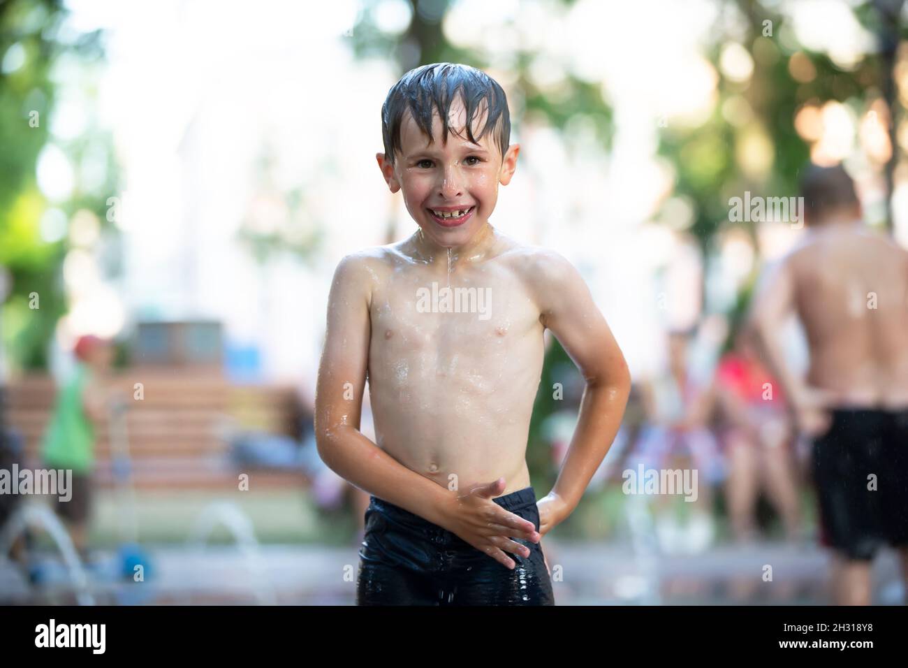 A little boy enjoys the cold waters of a fountain during the heat wave ...