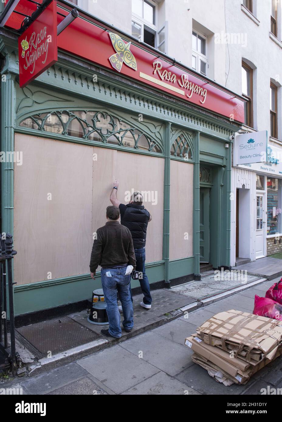 Workmen board up a restaurant windows in Soho, during the Corona Virus ...
