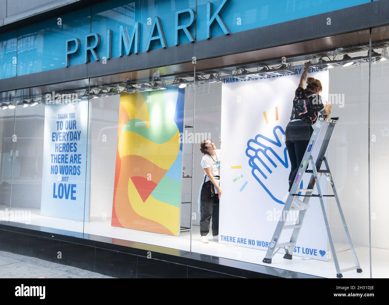 Primark window dressers prepare a shop window following the ...