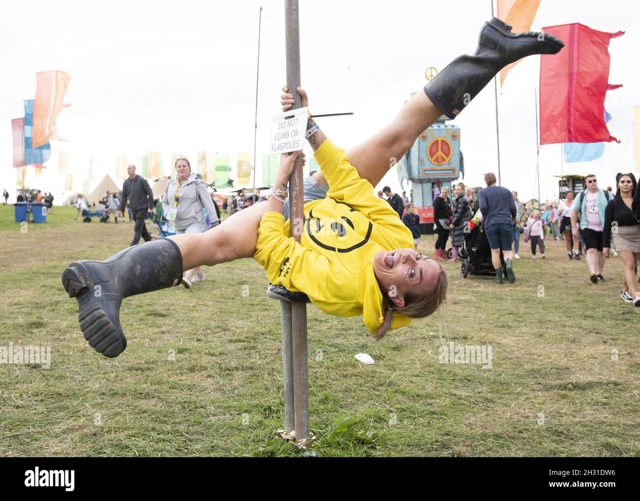 A festival goer pole dances on a flag pole on site on day 1 of Camp ...