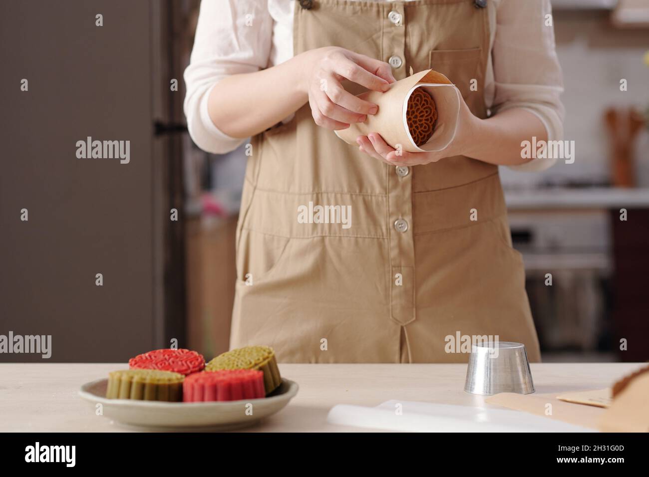 Cropped image of woman packing mooncakes in paper to give her family ...
