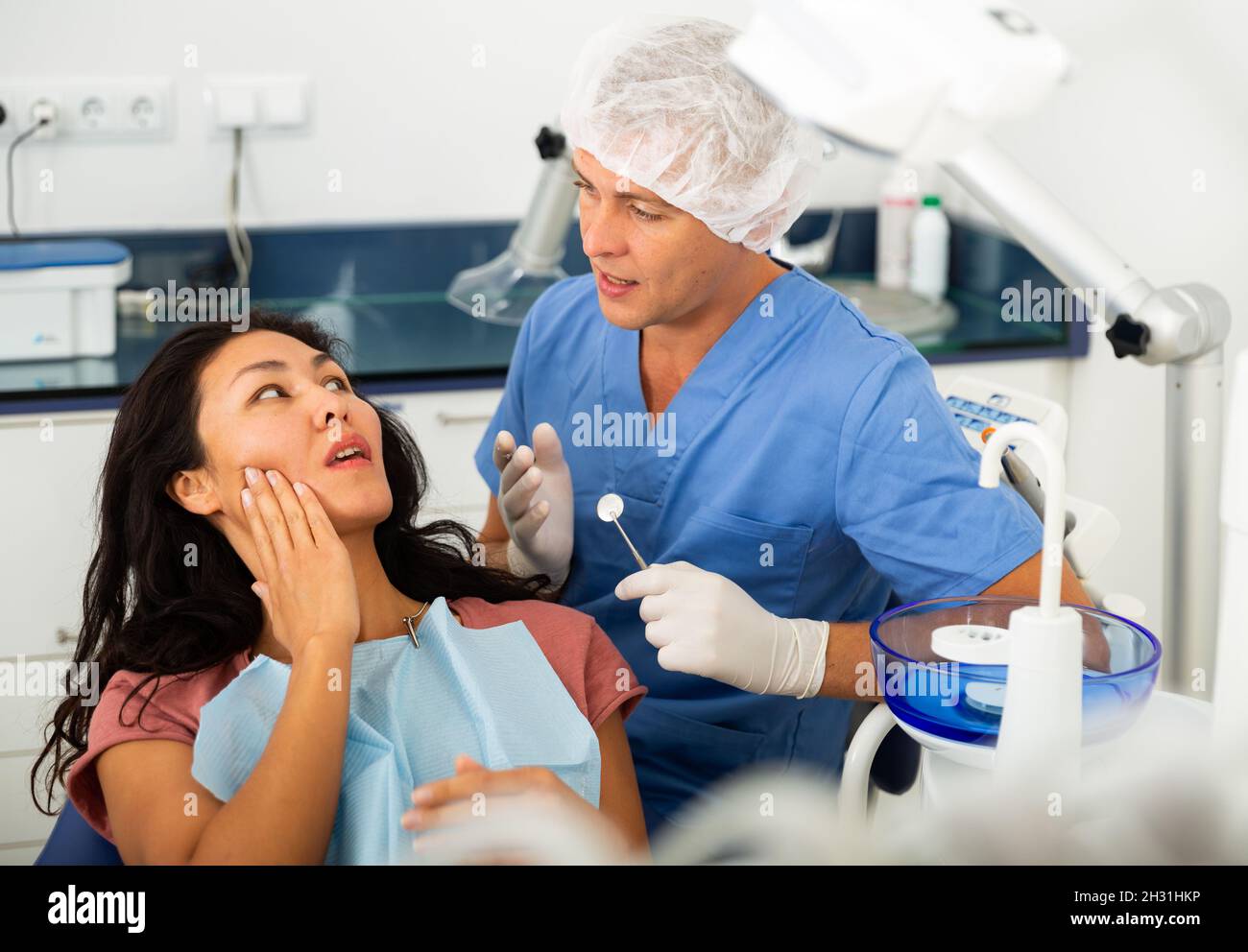 Female patient shows sick tooth to a dentist in dental clinic Stock ...