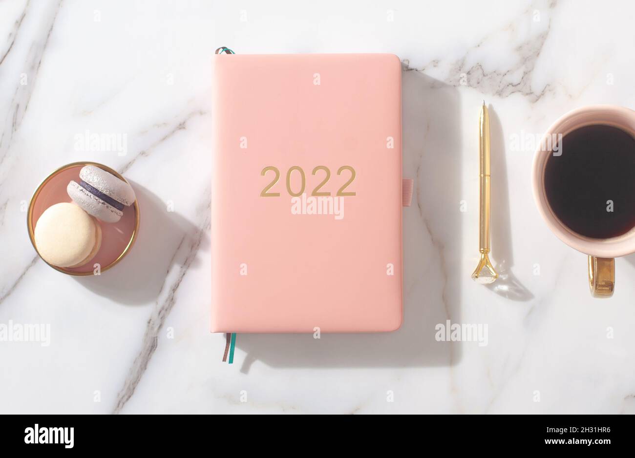 Pink coral colored diary for the year 2022, pen, coffee, macaron cookie ...