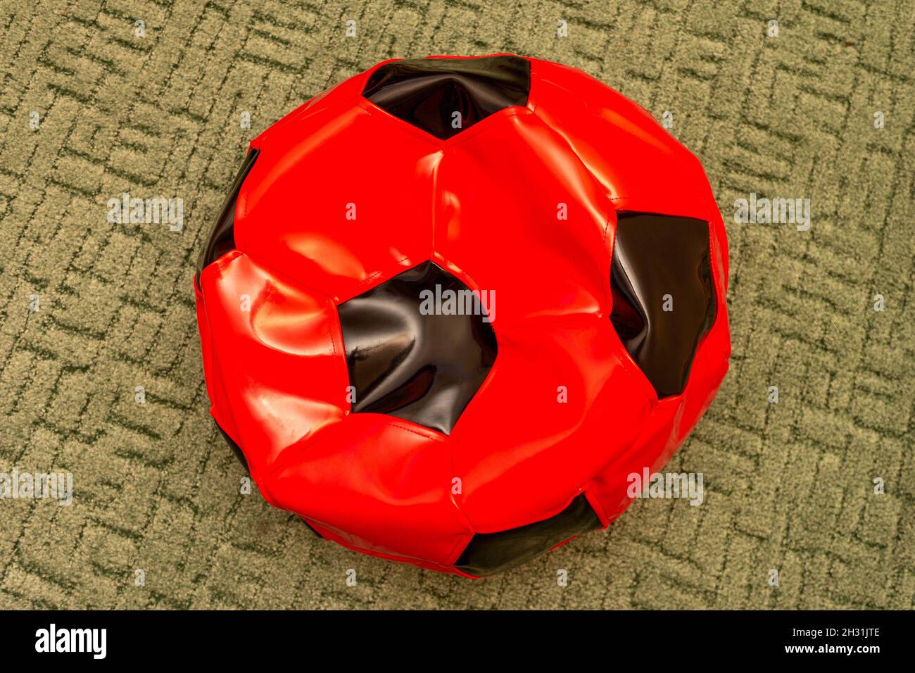 child beanbag chair in the form of a red football ball on the floor ...