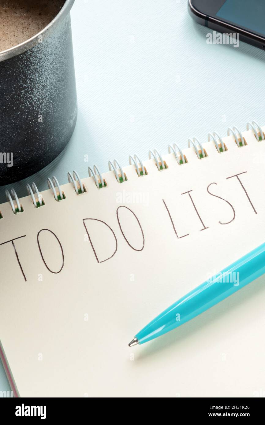 To do list concept. A paper notepad with a coffee mug and a blue pen ...