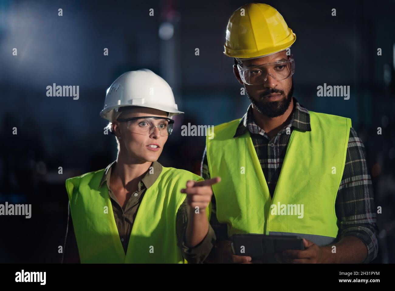 Portrait of industrial inspectors doing a general check up indoors at ...