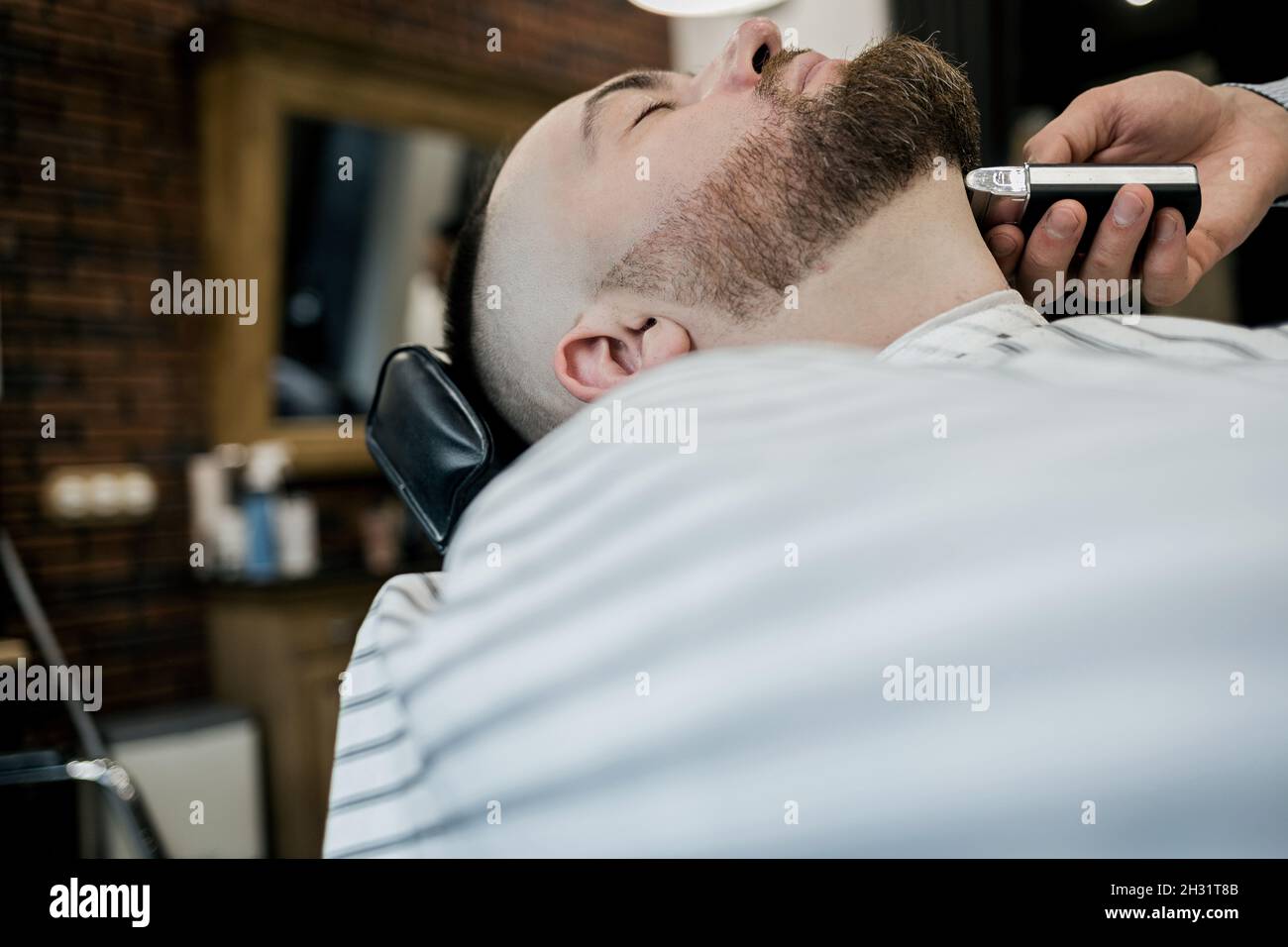 professional beard shaving in a barbershop. a man gets a haircut Stock ...