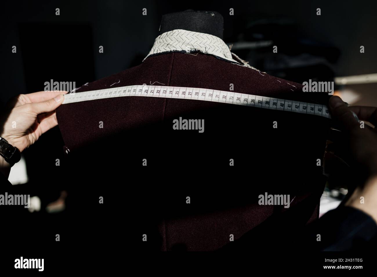 Tailor measuring the length of a jacket hi-res stock photography and ...