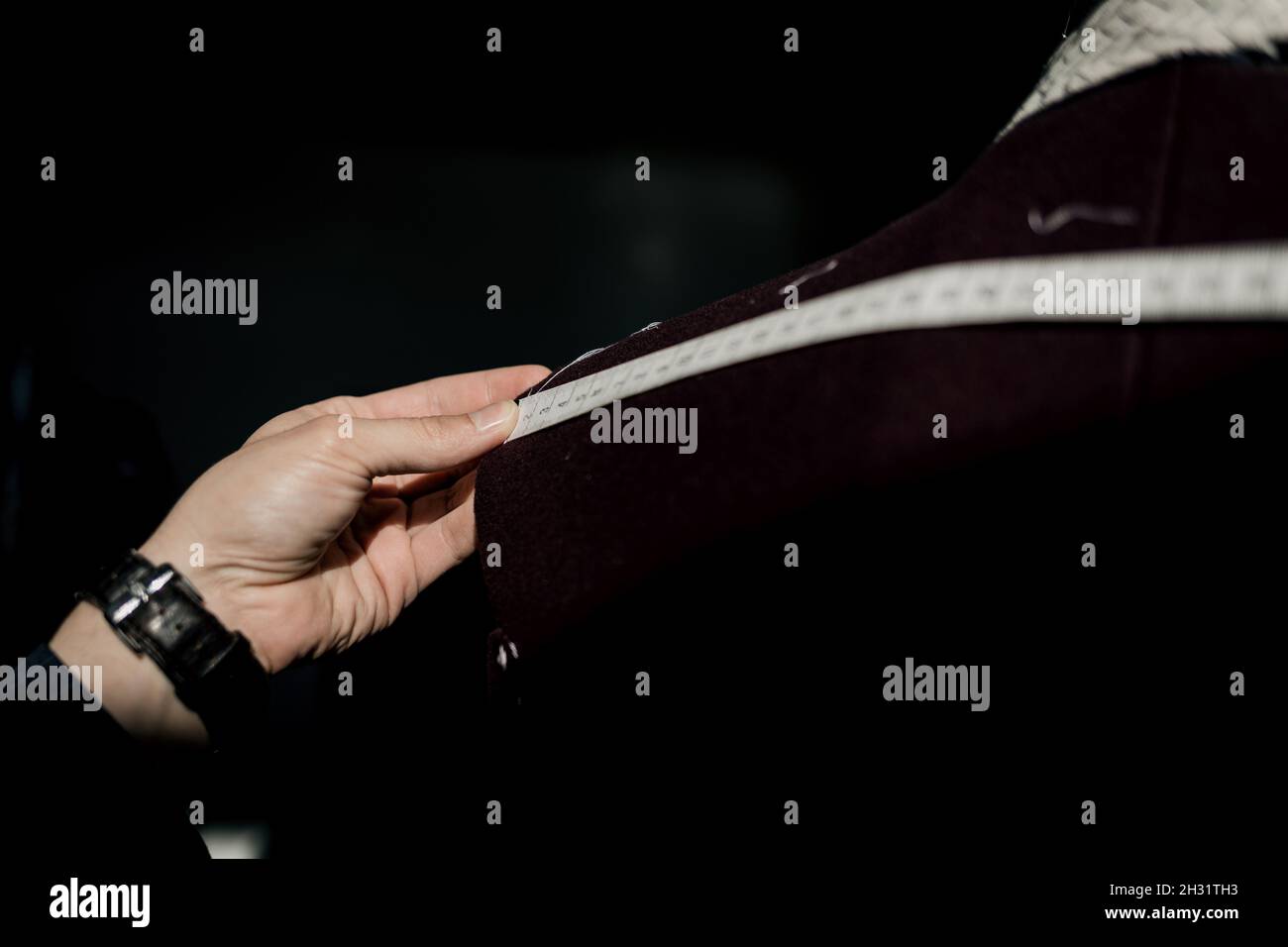 modern tailor measuring back length of bespoke suit during model ...