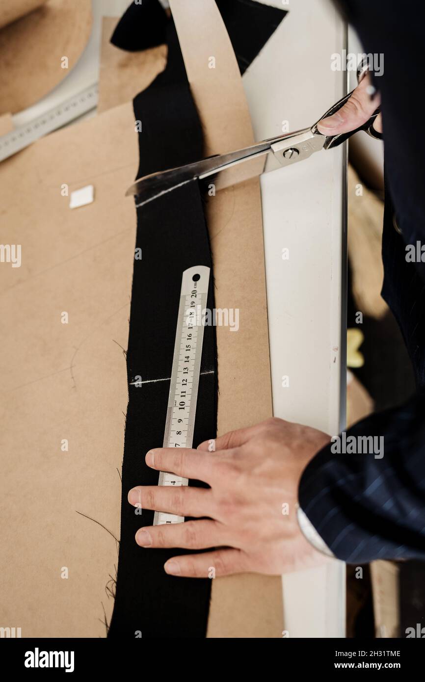 Tailor cutting fabric with scissors.Tailor atelier handmade exclusive ...