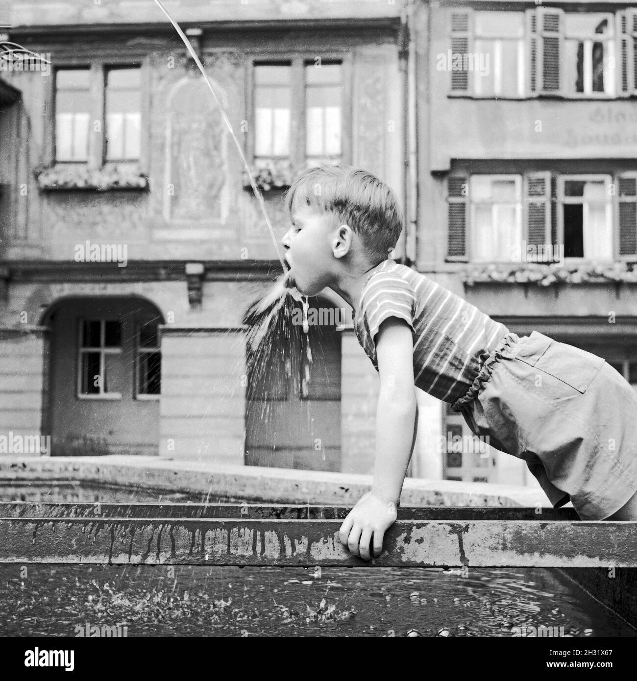 Ein Junge trinkt aus einem Marktbrunnen, Deutschland 1956. A boy ...