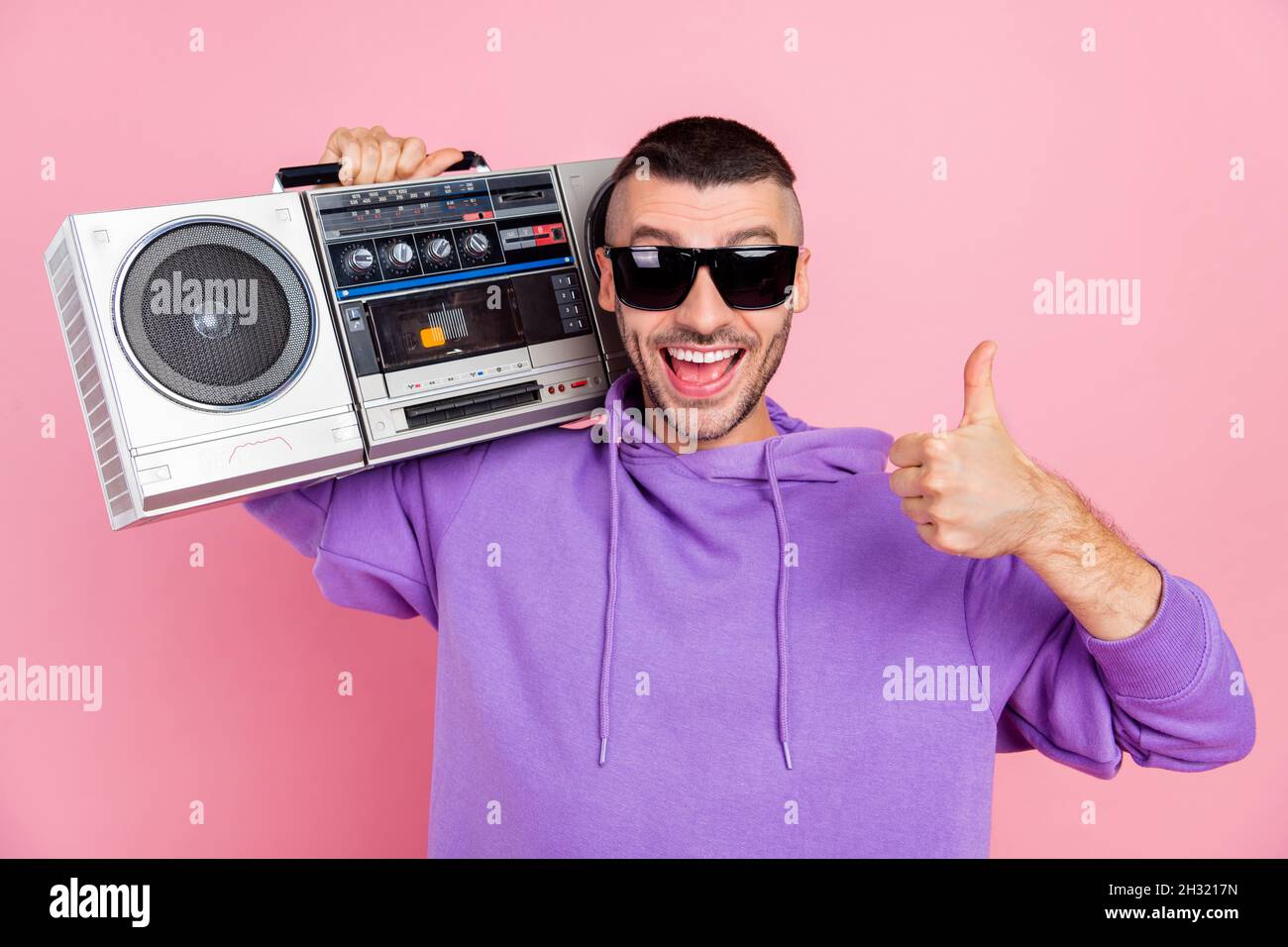Photo of young guy hold boombox show thumb-up great perfect sound ...