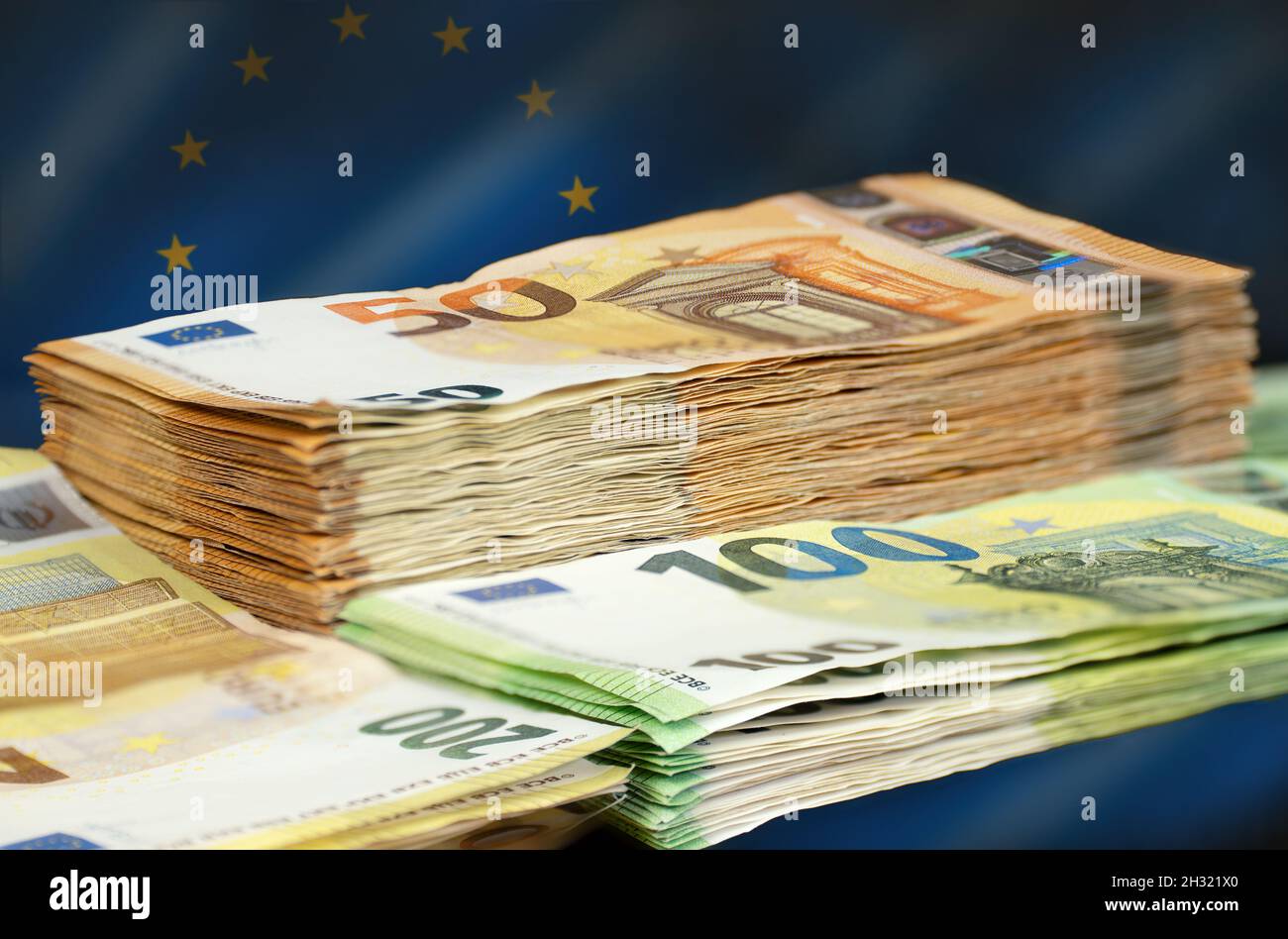 Stack of euro banknotes with EU flag in the background Stock Photo - Alamy