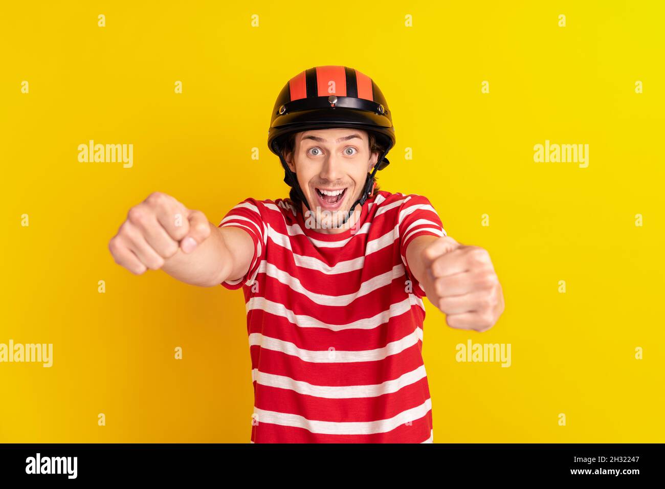 Portrait of attractive cheerful childish guy riding invisible car ...