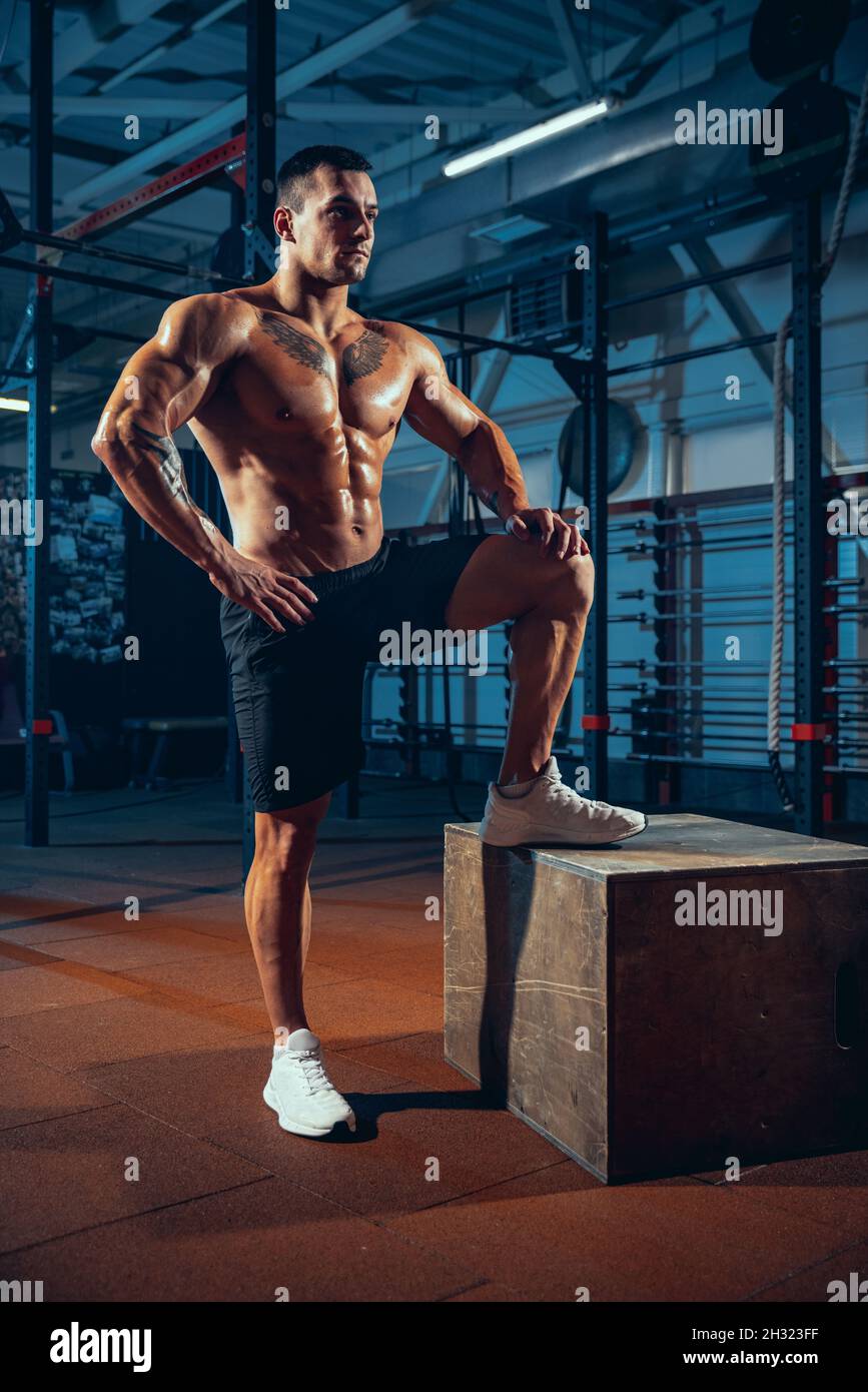 Portrait of handsome, sportive man, bodybuilder posing at sport gym ...