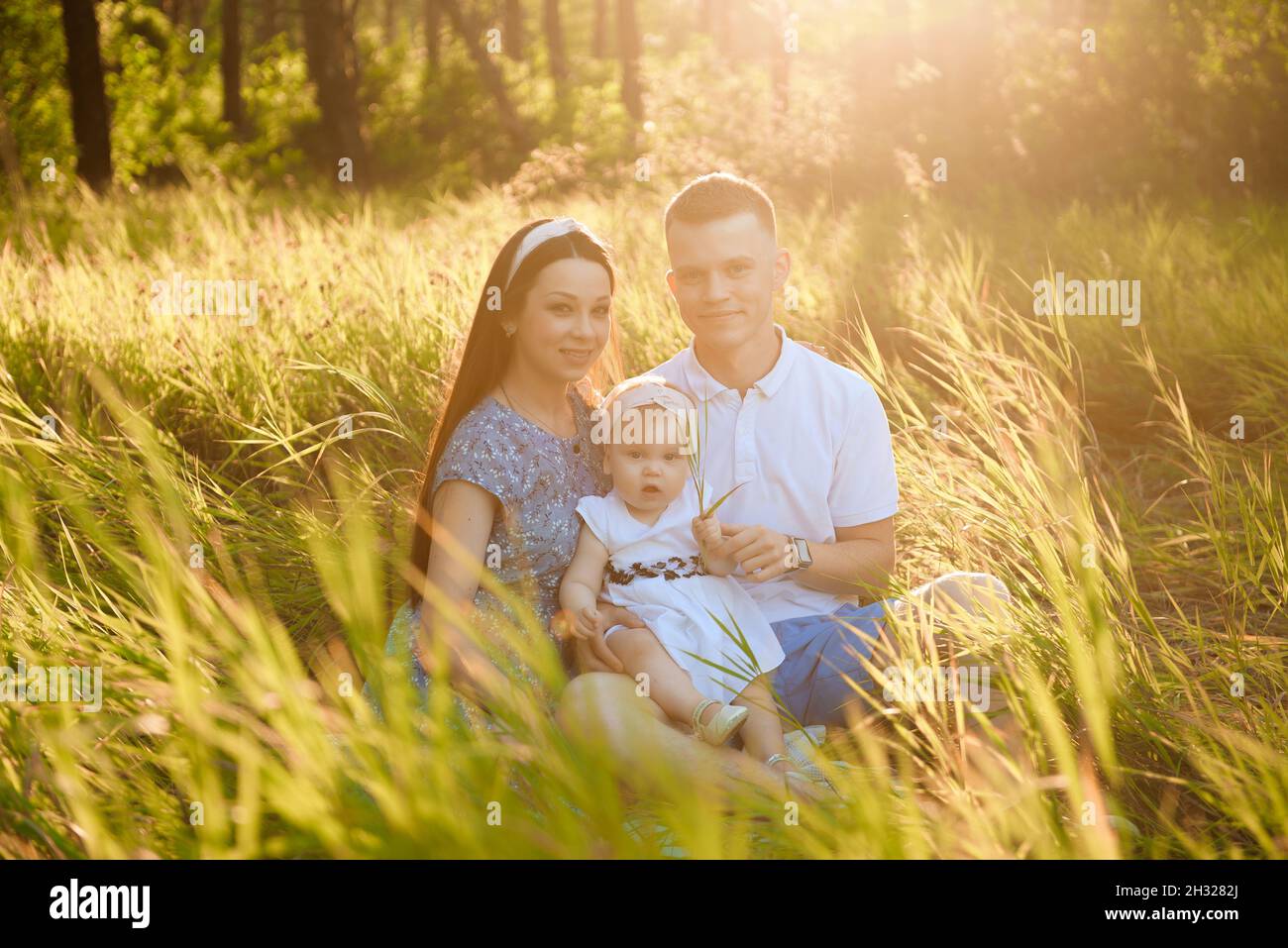 Happy family dad, mom playing in the fresh air on the field watching ...