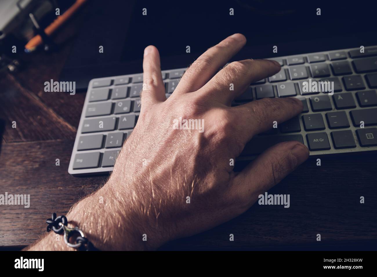 Male hand on desk with finger on computer keyboard Stock Photo - Alamy