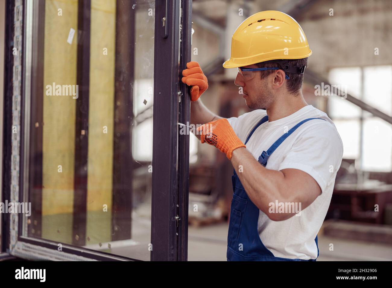 Male worker fixing door in building under construction Stock Photo - Alamy