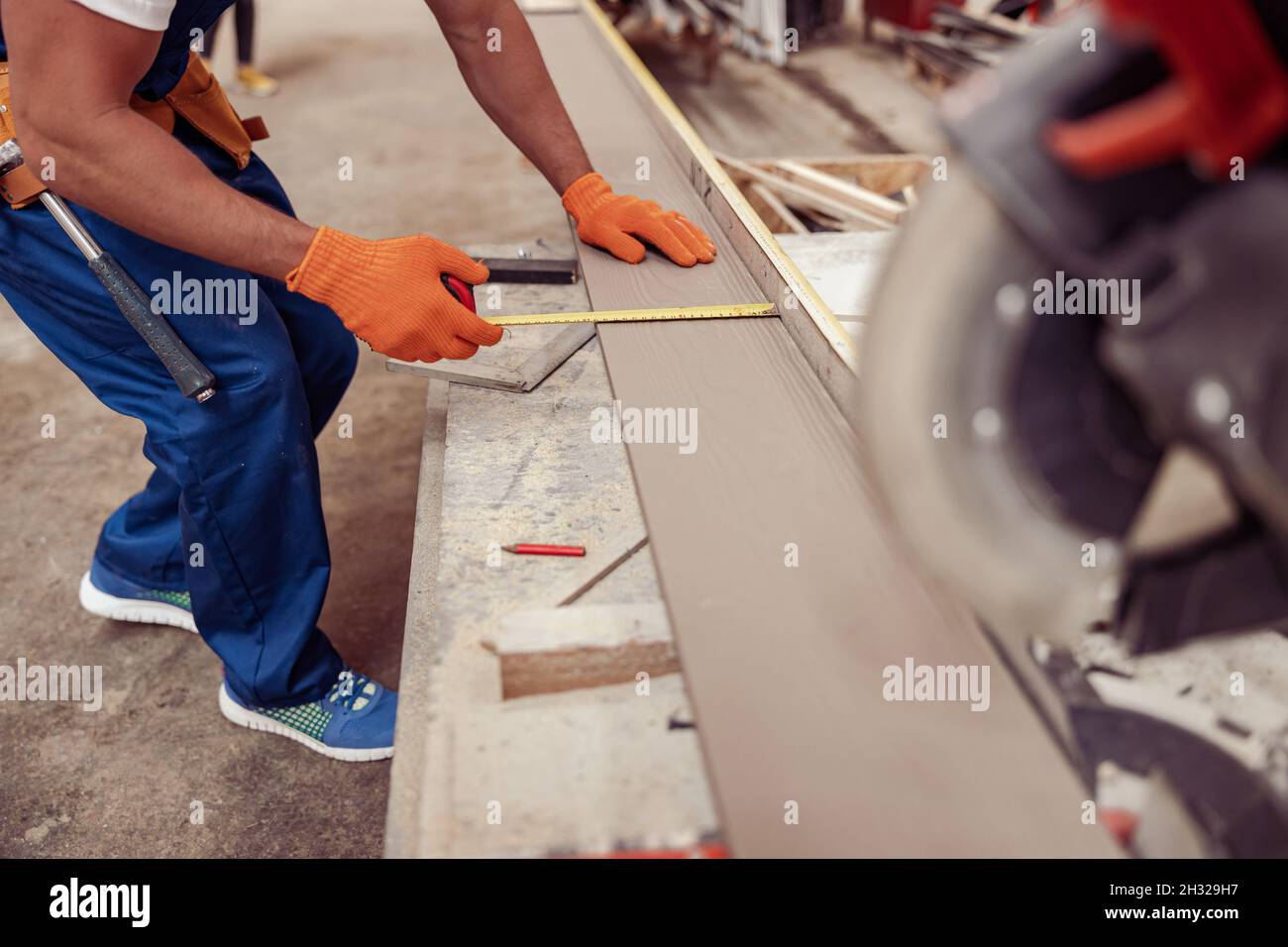 Male builder hands measuring wooden plank at construction site Stock ...