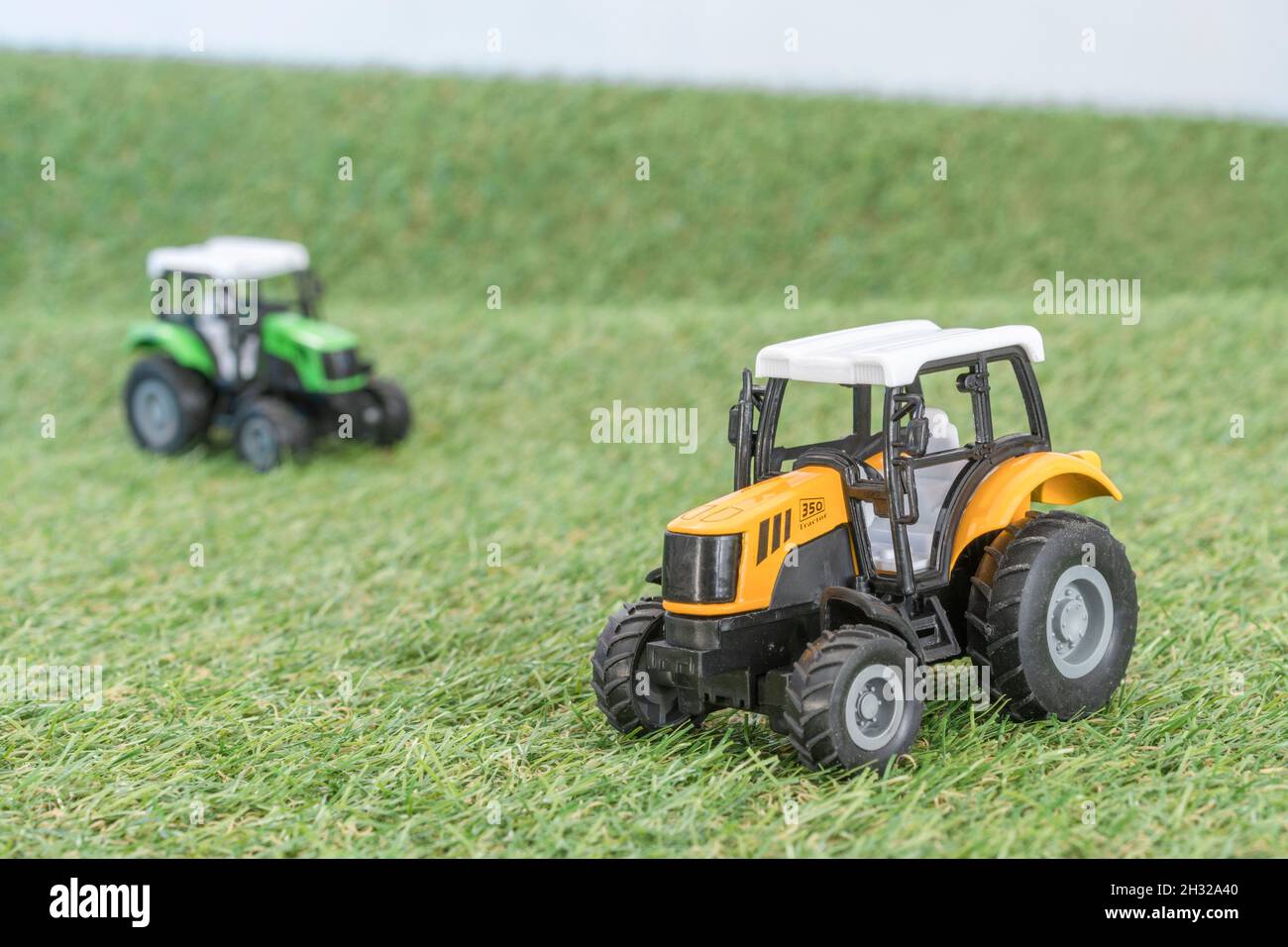 Small toy tractor standing in 'field' of faux / fake grass. For UK food ...