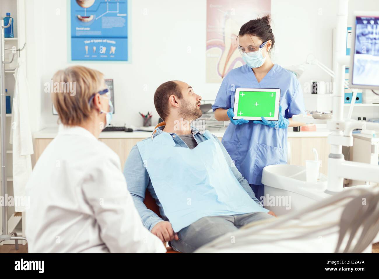 Sick patient looking at touchscreen gadget while speaking with ...